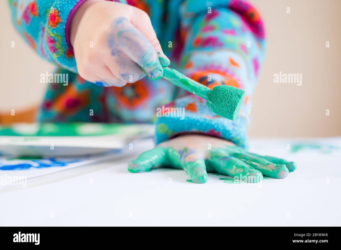 Detail view of child paiting her hand to make a mark Stock Photo - Alamy