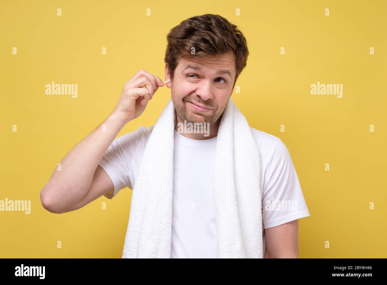 Caucasian man about to clean his ears using cotton swab. Hygiene ...