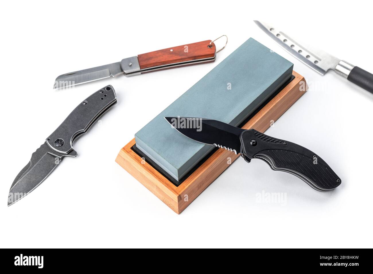 Various types of knives and a whetstone isolated on white background ...