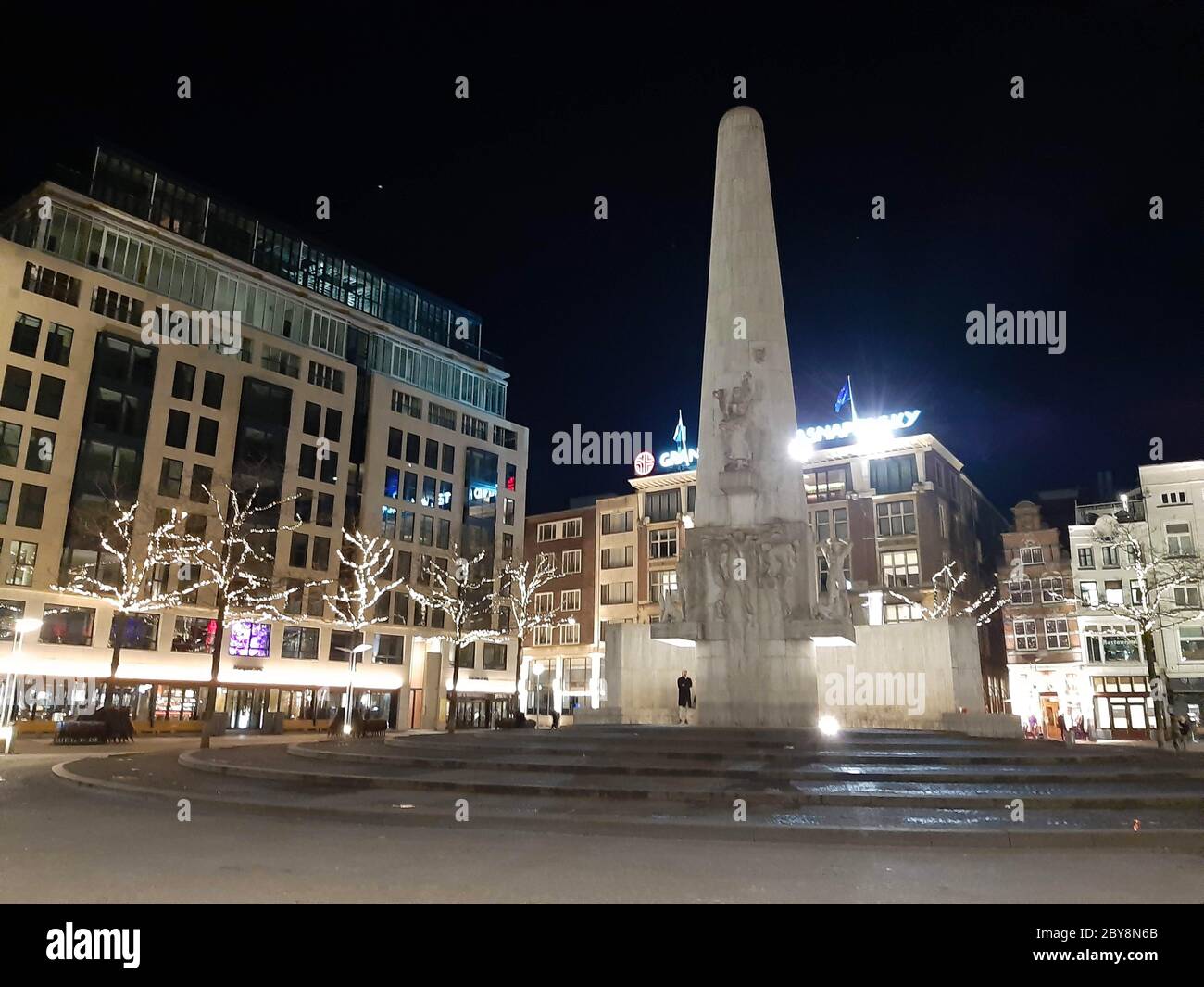 Dam square in Amsterdam at night with illuminated deserted streets and ...