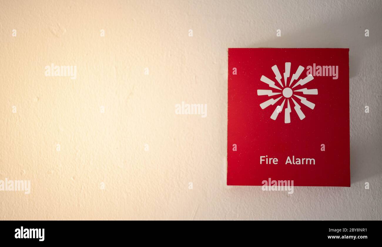 Red fire alarm sign on the white wall for safety first and sign for ...