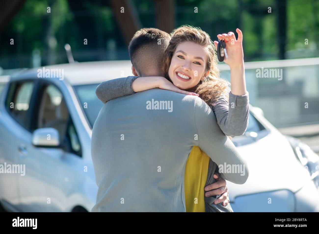 Grateful joyful girl with a key hugging a man Stock Photo - Alamy