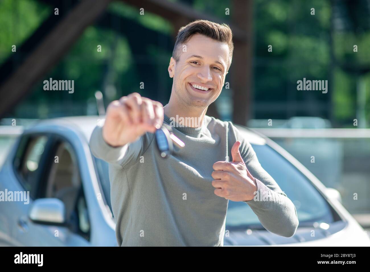 Happy man with car key on the street Stock Photo - Alamy
