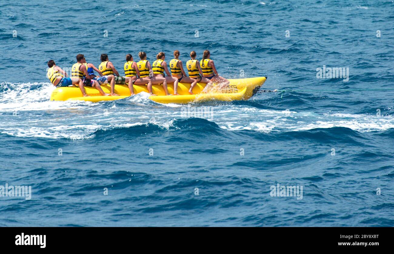 People riding banana boat at sea Stock Photo - Alamy