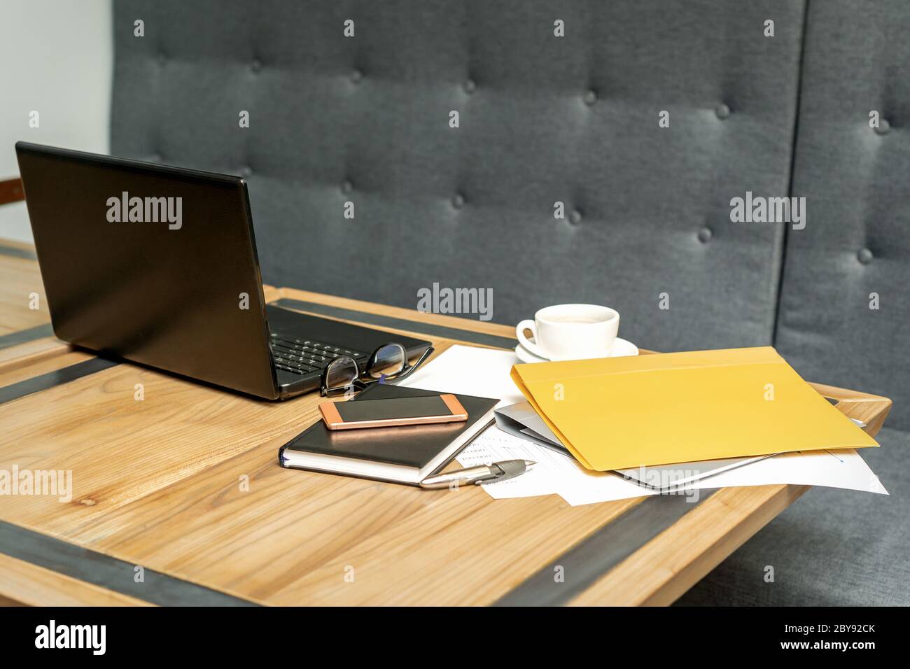 Office workplace with laptop, cup of coffee and paperwork without ...