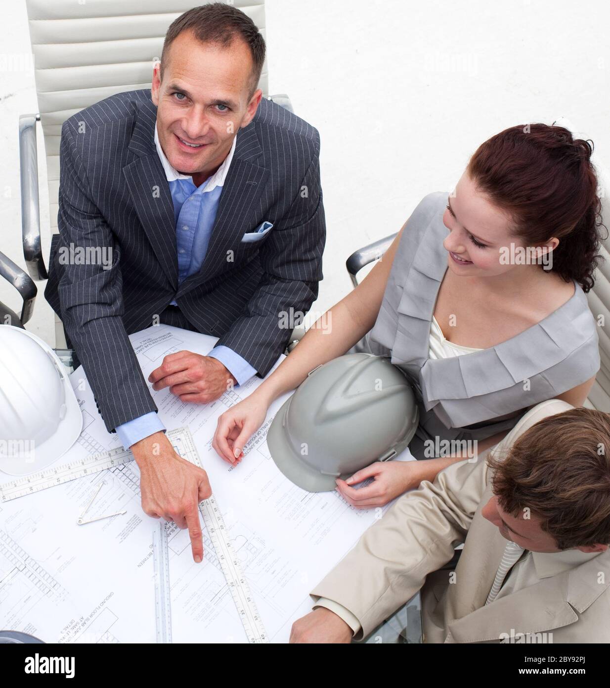 Architect man pointing at a plan in a meeting Stock Photo - Alamy