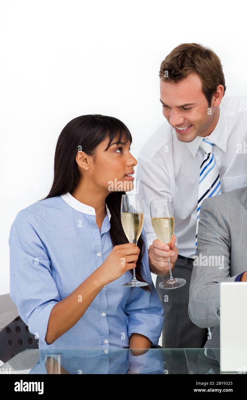 Two cheerful colleagues toasting with Champagne in the office Stock ...