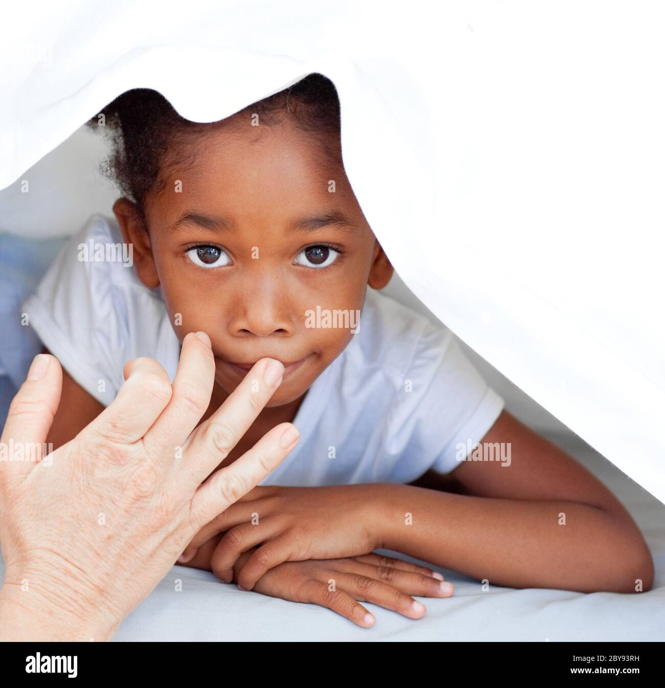 Portrait of a lovely little girl hidden under cover Stock Photo - Alamy