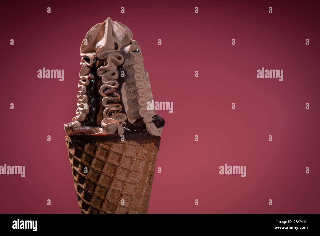 Decorative chocolate ice cream dessert in a wafer cone drizzled with ...