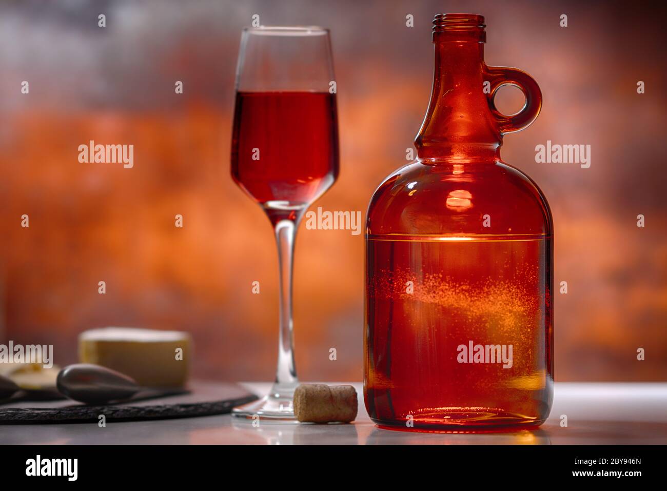 Glass of red wine, decanter and cheese board on a bar or tavern counter ...
