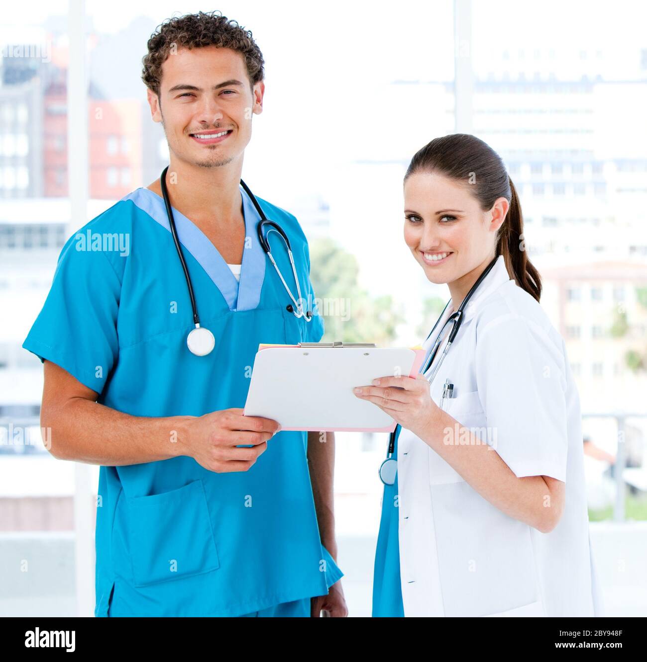 Smiling partners holding a patient diagnosis Stock Photo - Alamy