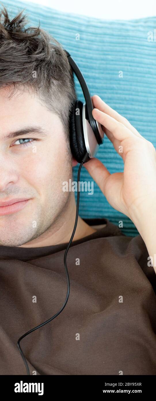 Charming young man listening to music with headphones Stock Photo - Alamy