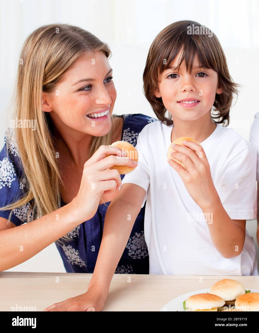 Attractive mother and her son eating burgers Stock Photo - Alamy
