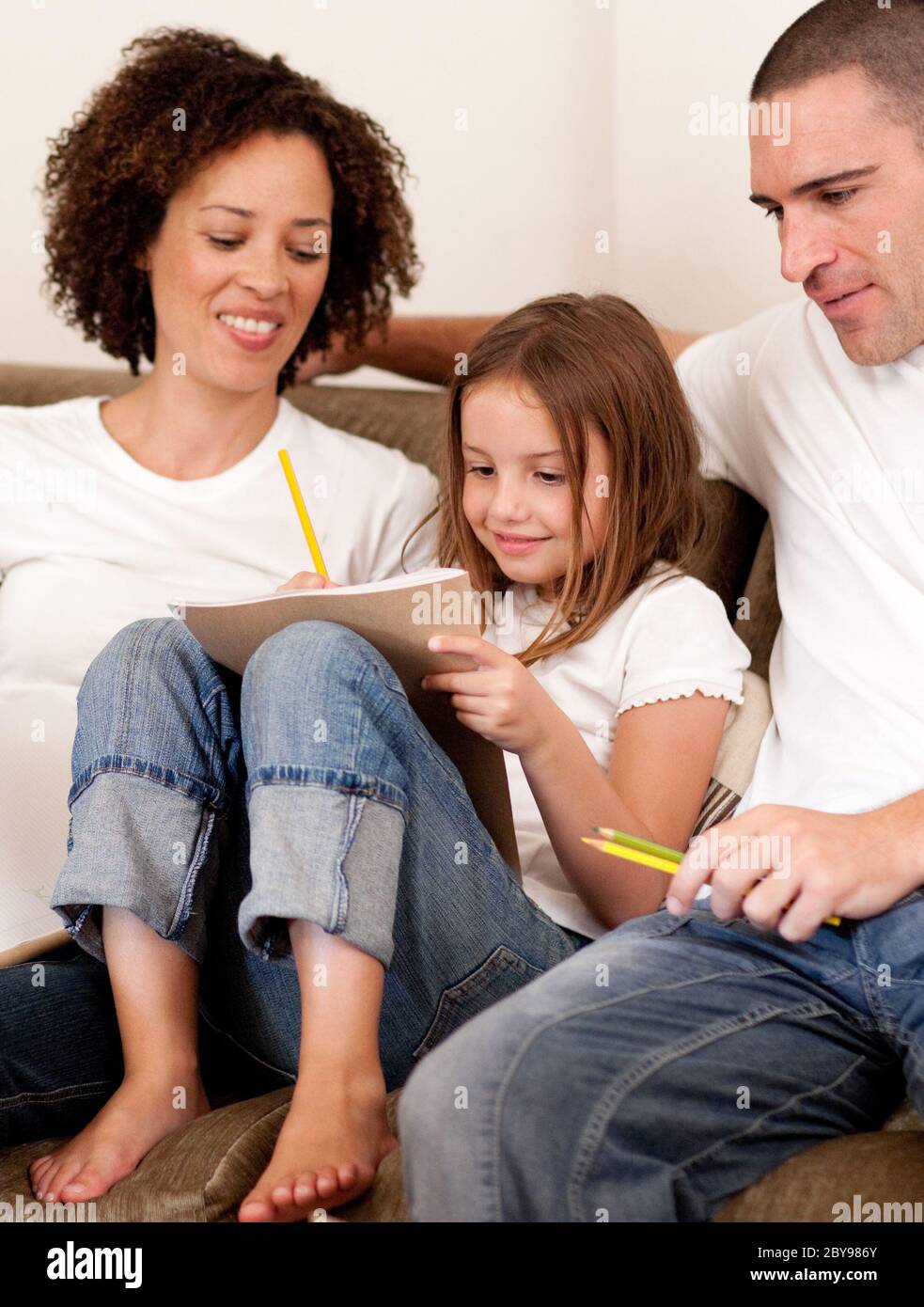Cute girl sitting between her parents Stock Photo - Alamy