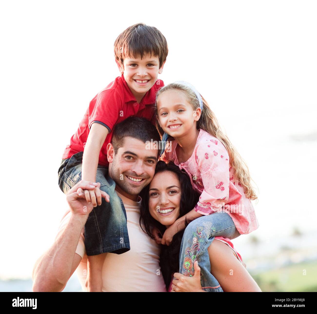 Parents giving children piggyback rides Stock Photo - Alamy