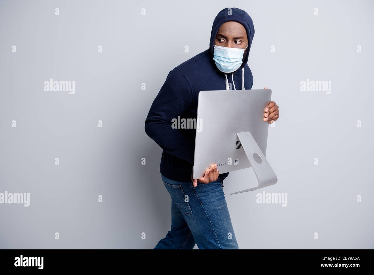 Profile photo of dark skin african thief carry stolen tv monitor look ...