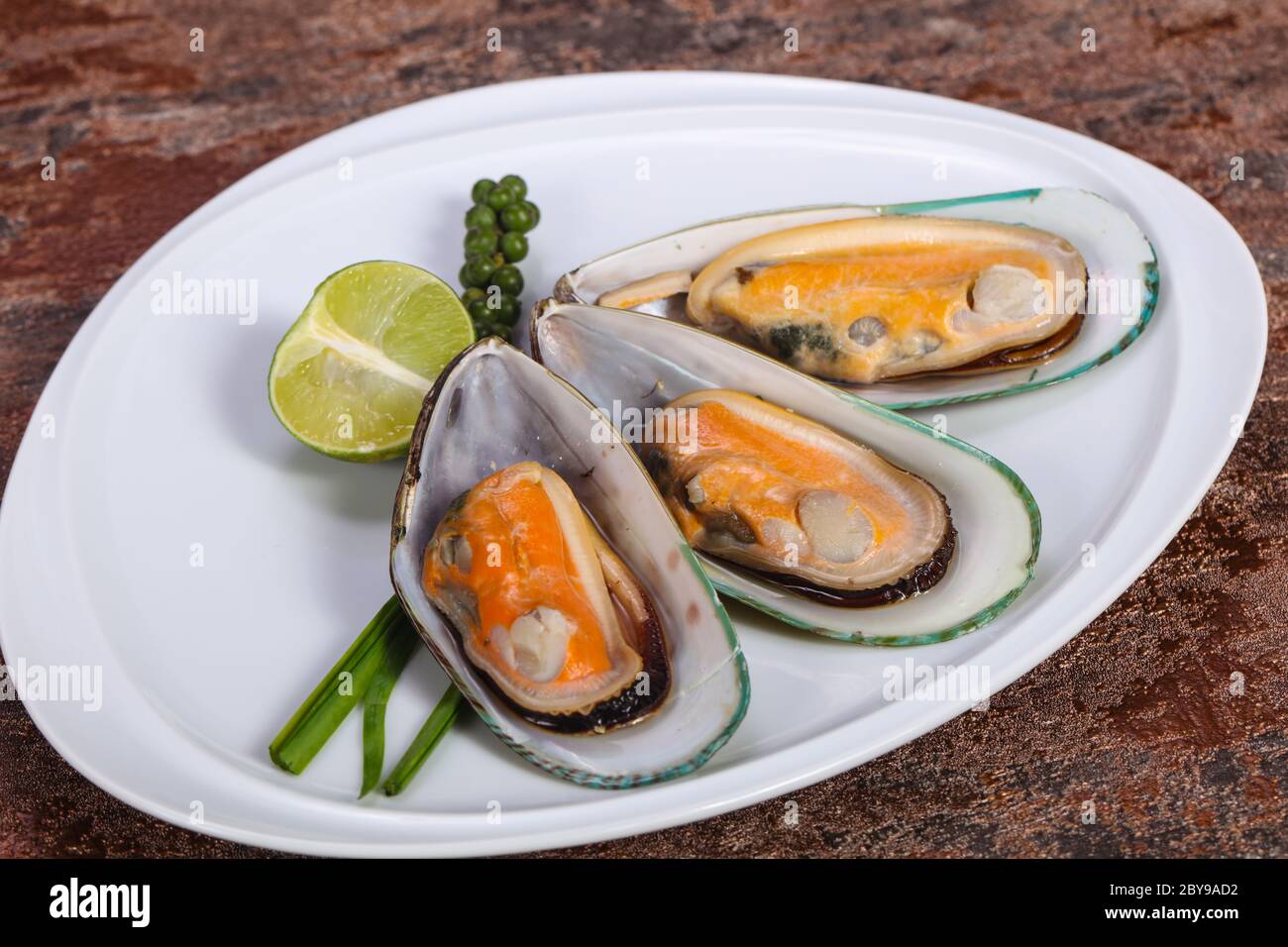 Half mussels with lime and green pepper Stock Photo - Alamy
