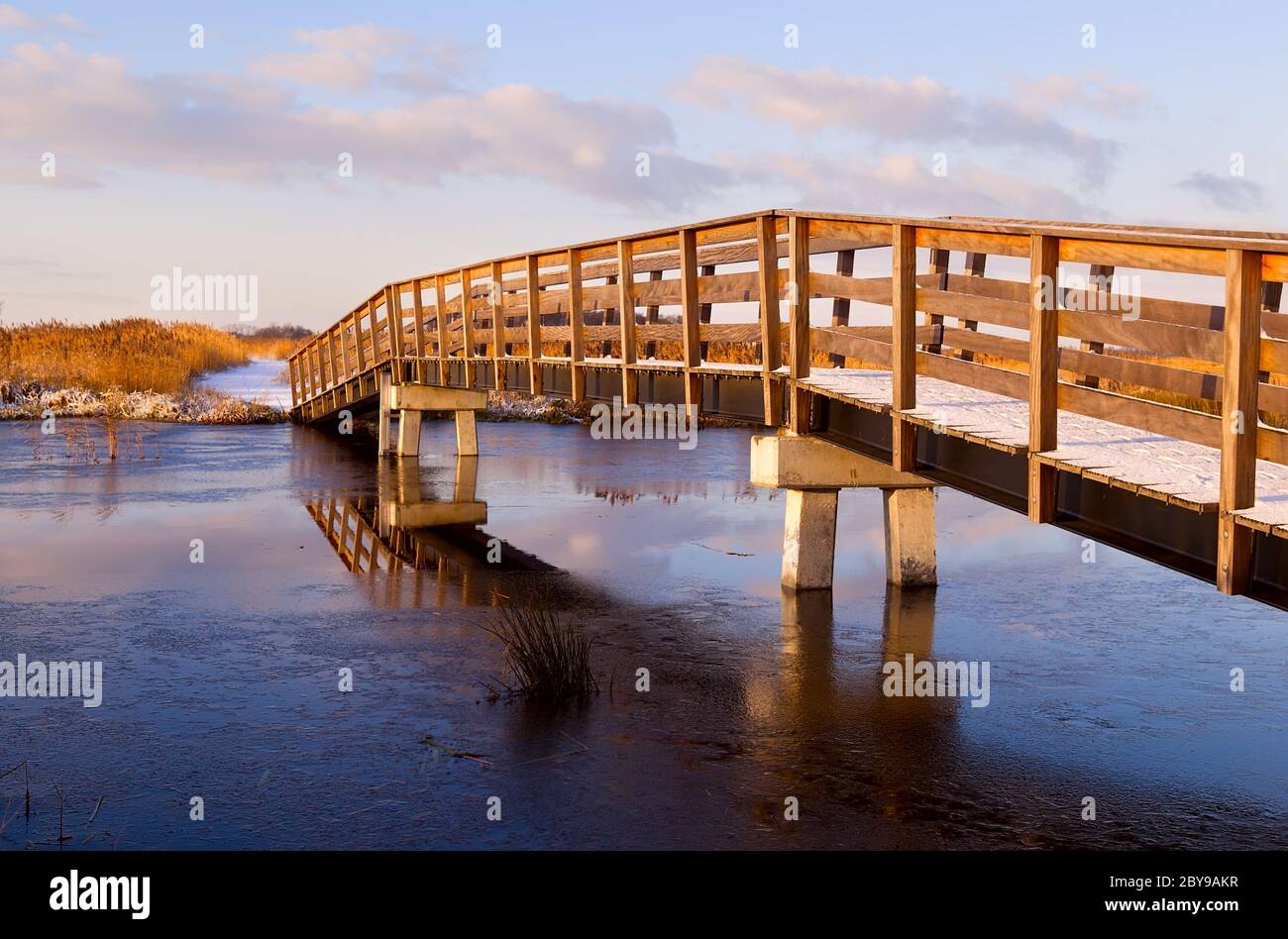 wooden bridge through frozen river Stock Photo - Alamy