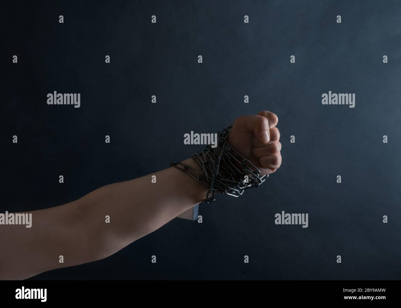 Fist of Hand are chained in chains on the black background, concept of ...