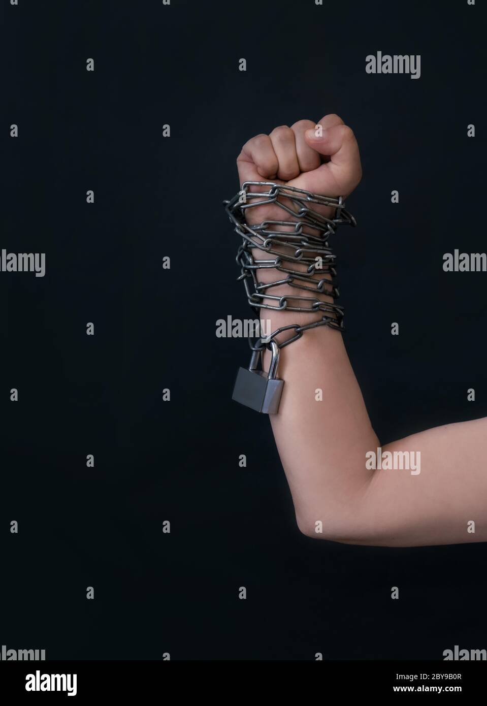 Fist of Hand are chained in chain on the black background, concept of ...