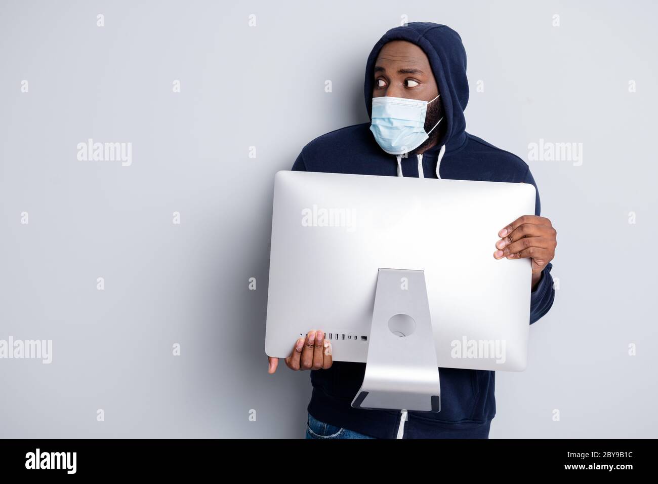 Photo of dark skin african thief carry stolen tv monitor look back ...