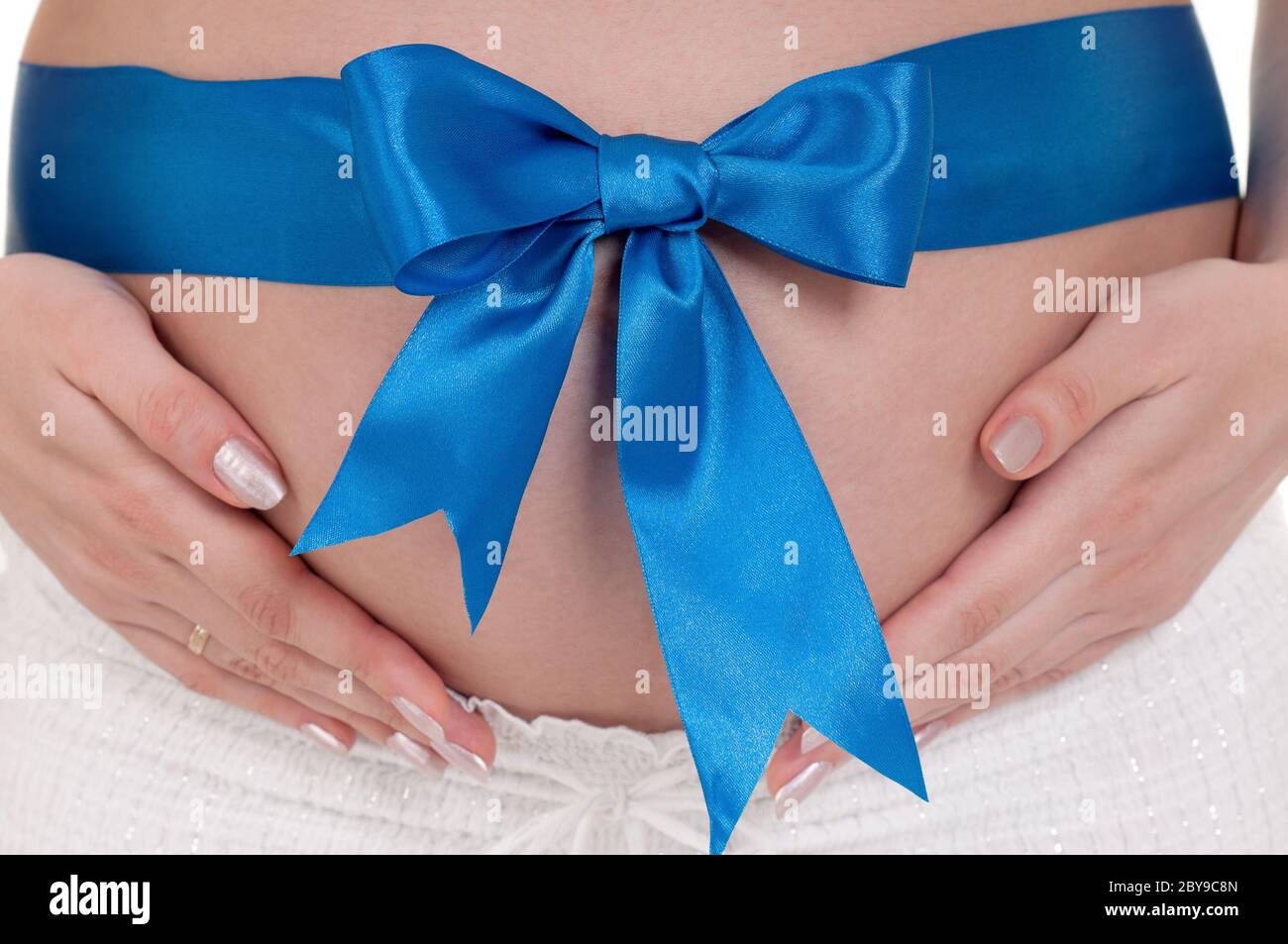 Pregnant belly with blue ribbon Stock Photo - Alamy