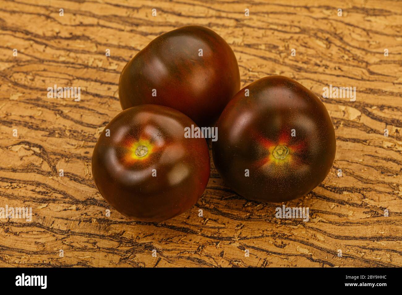 Black tasty juicy kumato tomato heap Stock Photo - Alamy