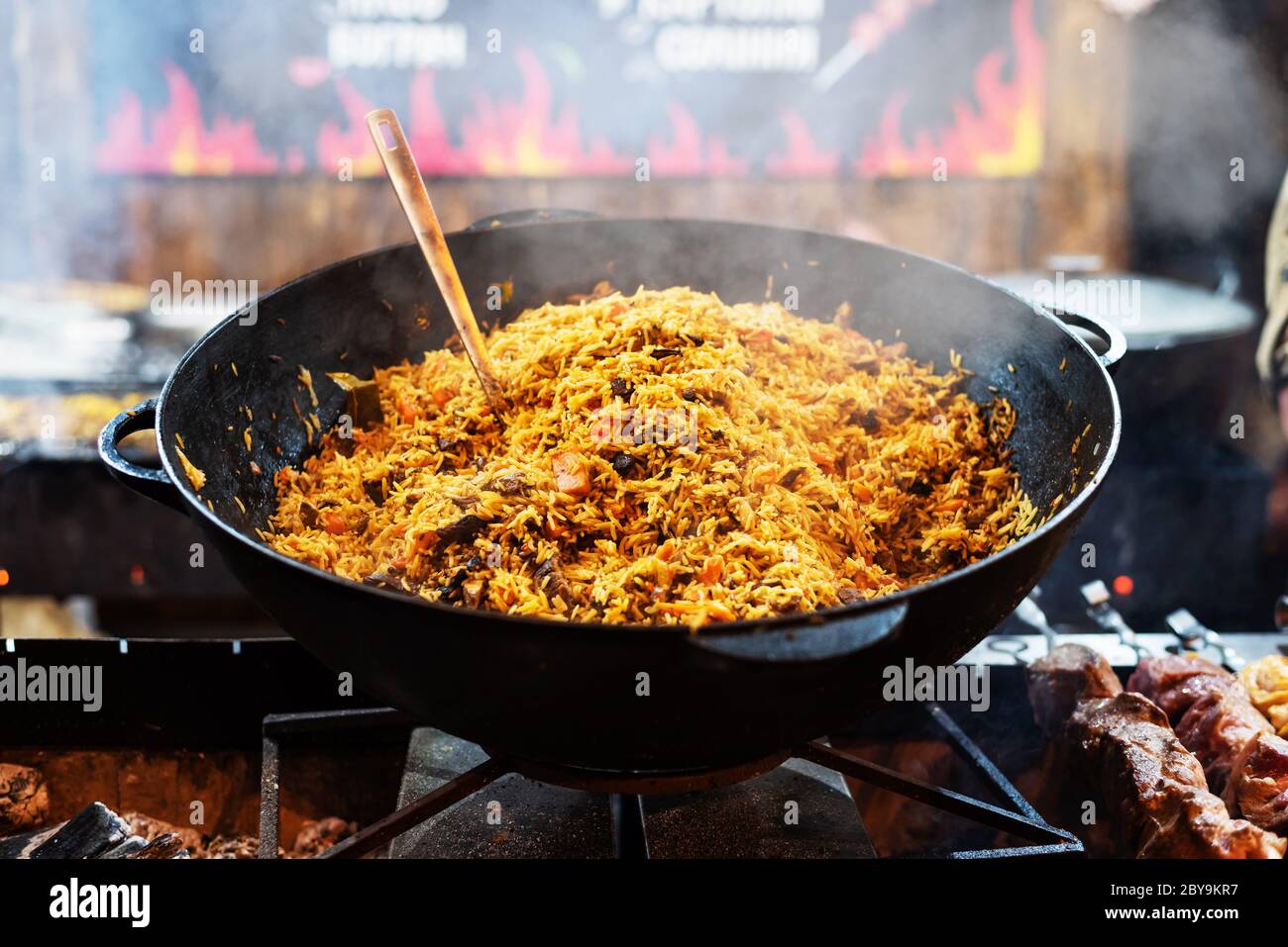 Hot pilaf in large cauldron outdoors. Traditional oriental food. Street ...