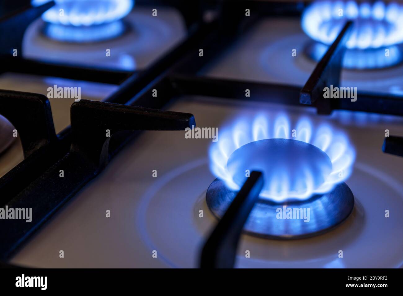 Burning blue flames gas. Focus on the front edge of the gas burners ...