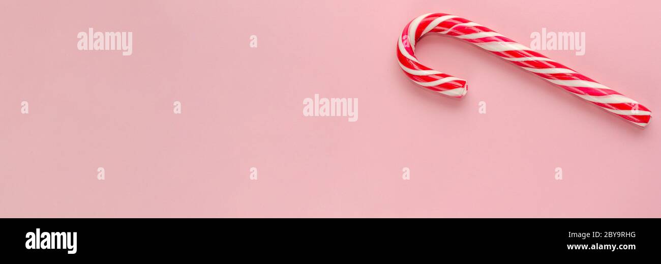 Single candy cane on pink background. Banner. Sweet Christmas symbol ...