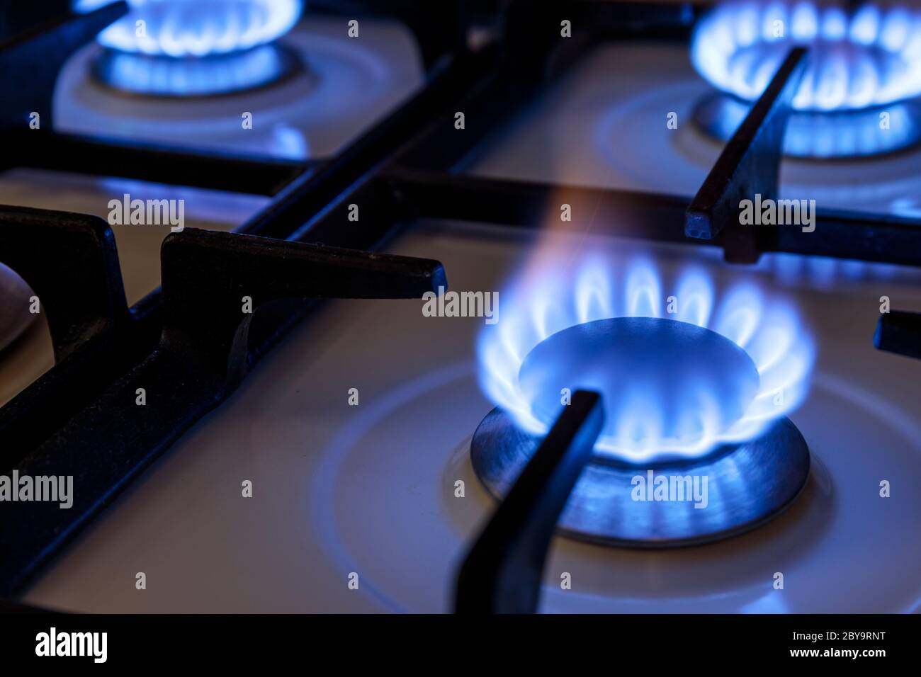Burning blue flames gas. Focus on the front edge of the gas burners ...