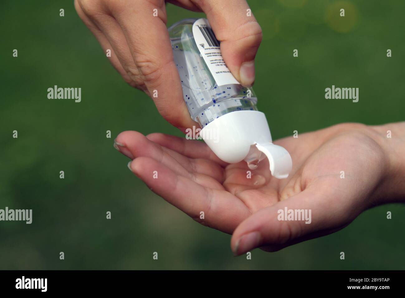 Hand applying alcohol hand sanitiser onto palm during Covid 19 pandemic ...