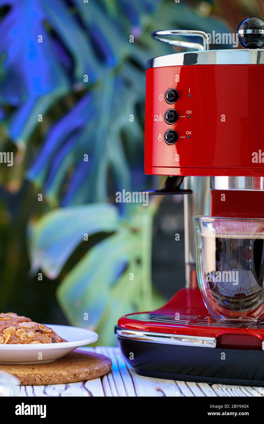 Red coffee machine with a glass on kitchen counter Stock Photo - Alamy