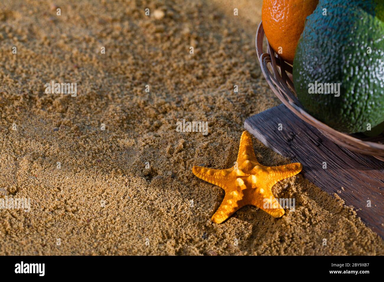Ripe southern fruits lie in the basket. Sea shore of a sandy beach ...