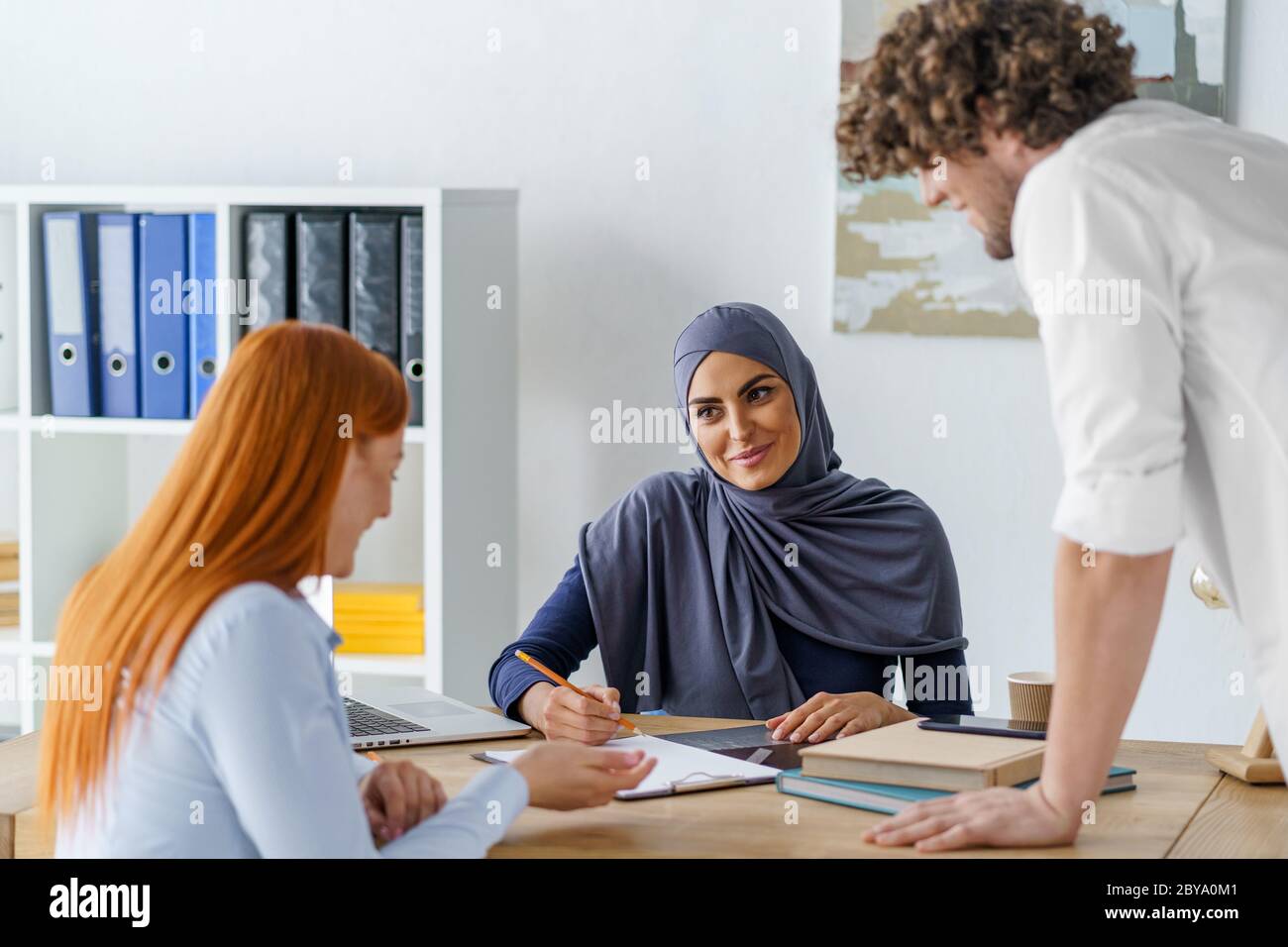 Female Muslim boss discussing a project with her employees Stock Photo ...
