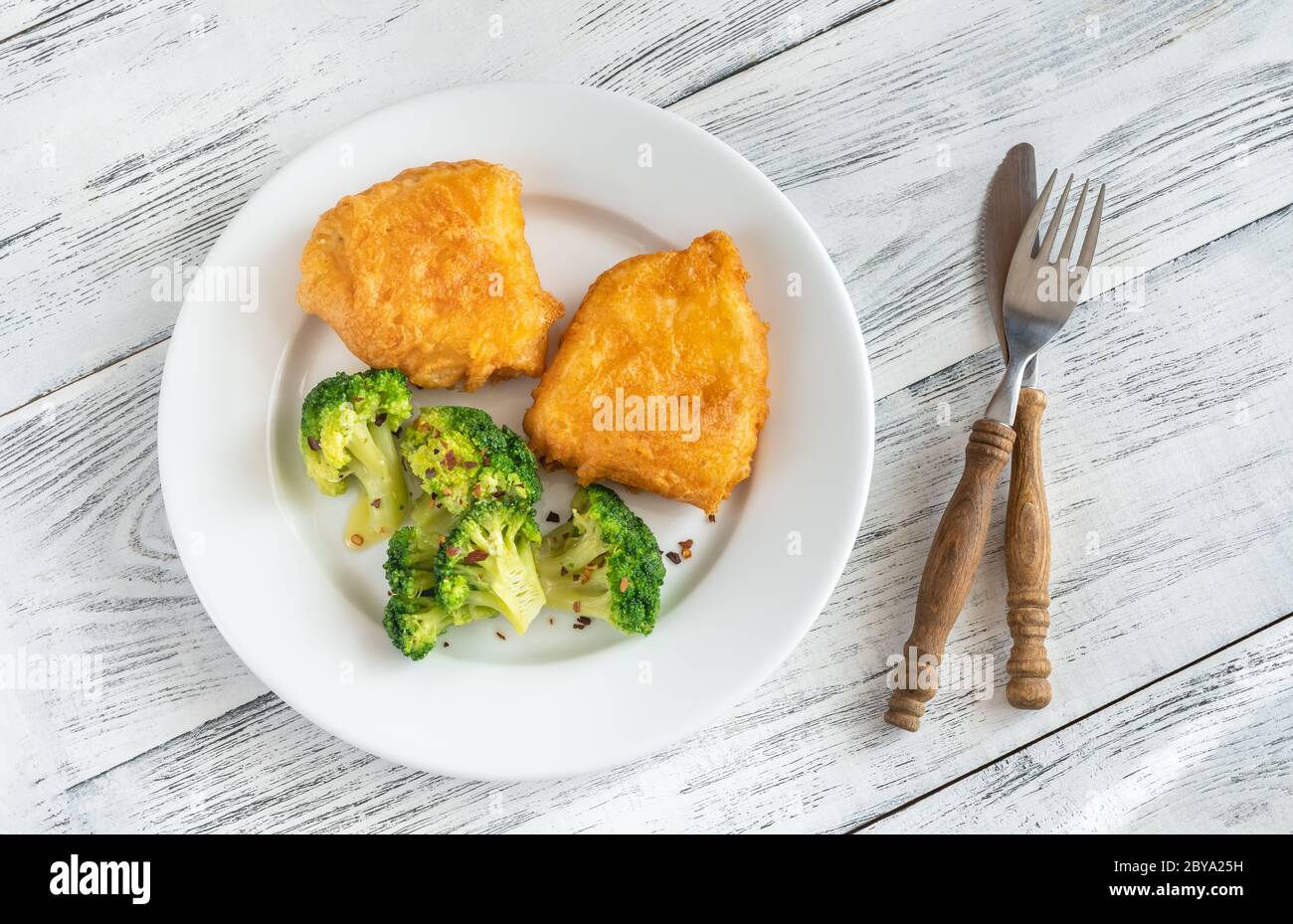 Portion of battered fish with steamed broccoli Stock Photo - Alamy