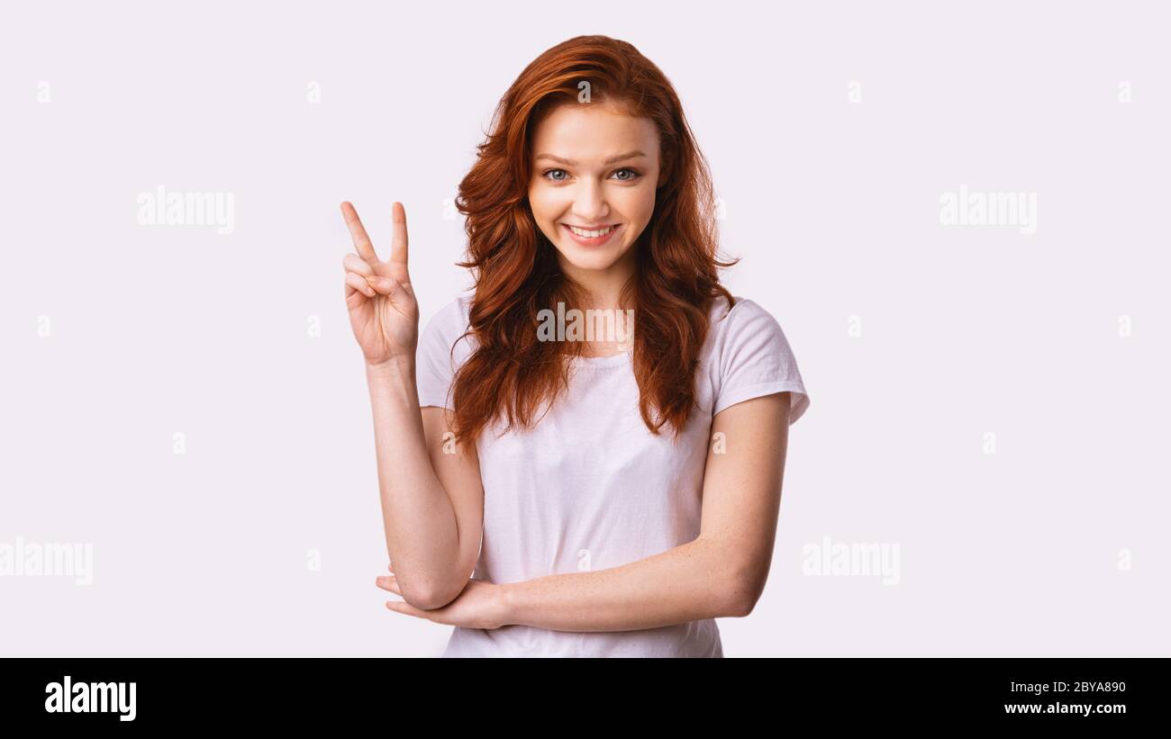 Young girl smiling victory sign hi-res stock photography and images - Alamy