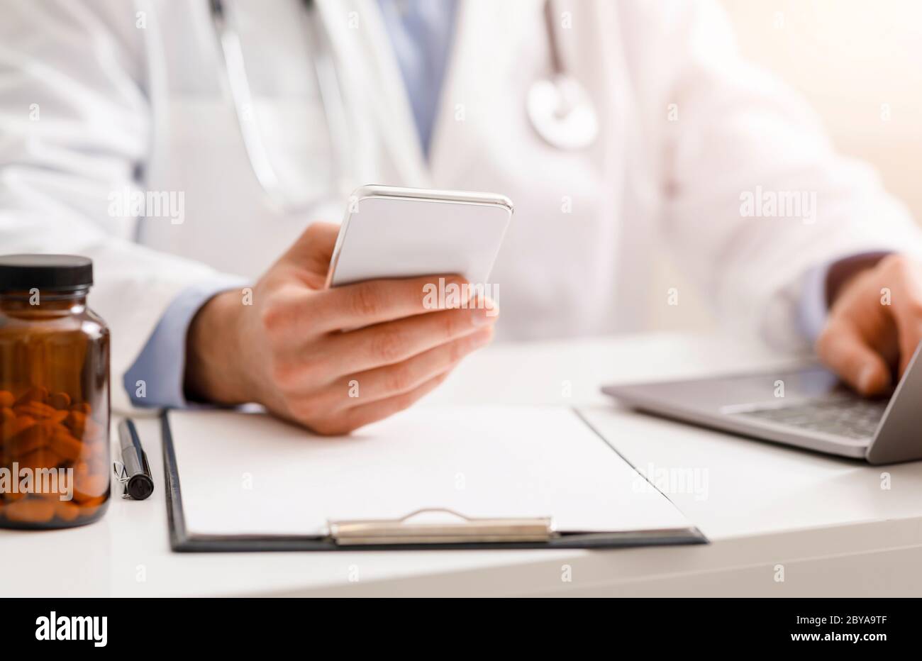 Medical doctor using his cellphone in office Stock Photo - Alamy