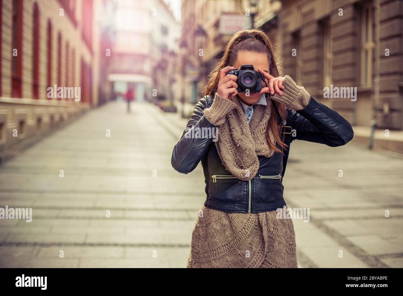 Pretty young female tourist photographer taking pictures in the city ...