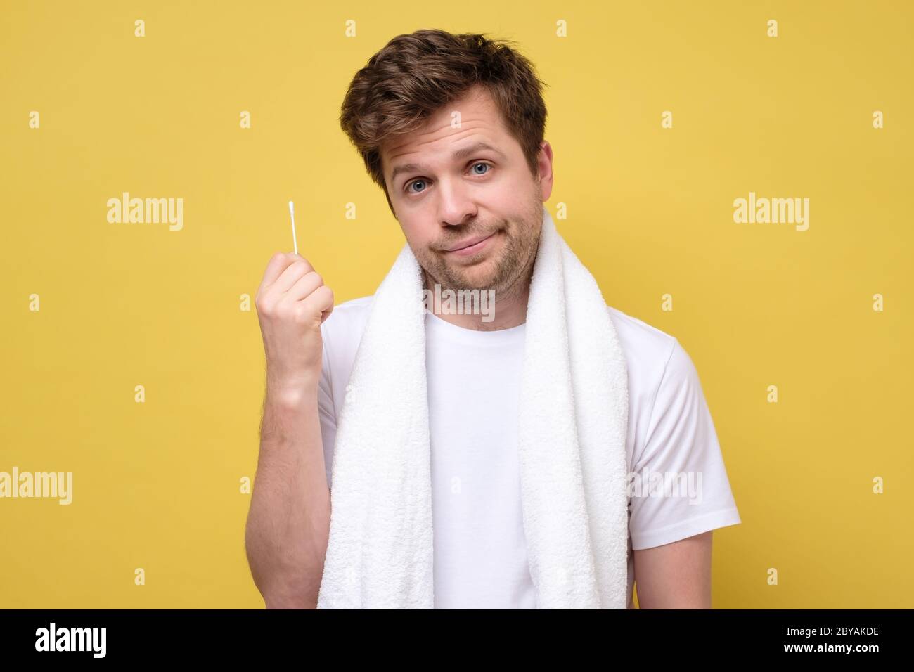 Caucasian man about to clean his ears using cotton swab. Hygiene ...