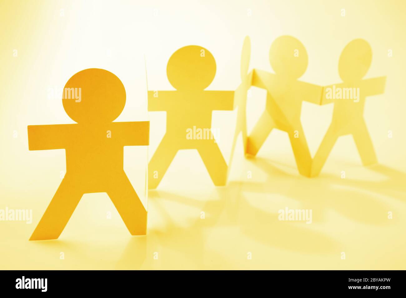 Paper chain team holding hands. Teamwork. Partnership Stock Photo - Alamy