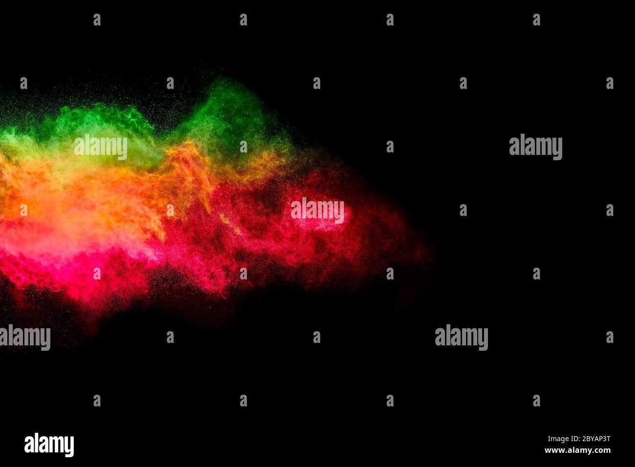 Colorful dust particle explosion over black background. Closeup of a ...