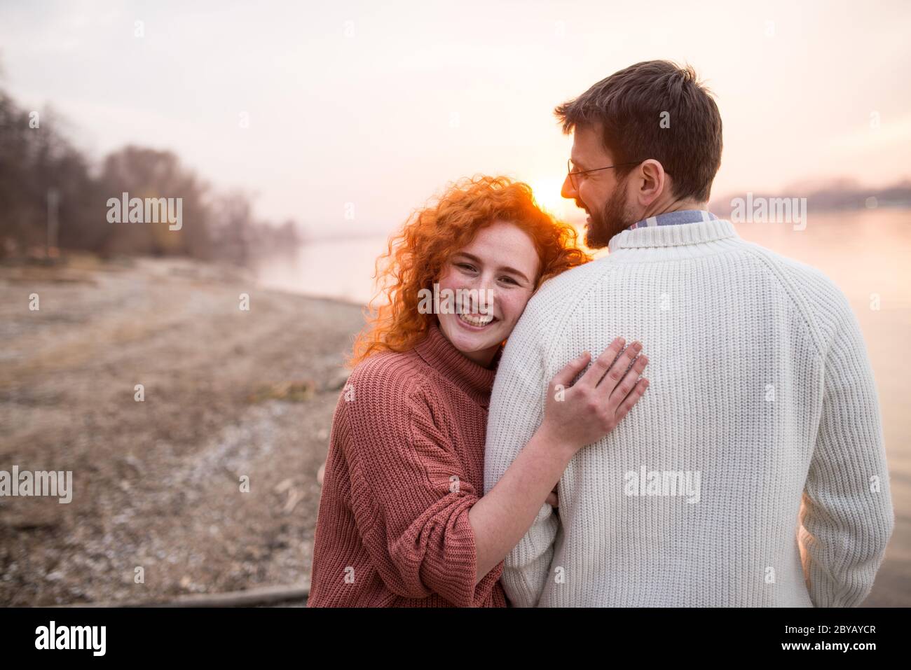 Couple cuddling while enjoying beautiful sunset together Stock Photo ...