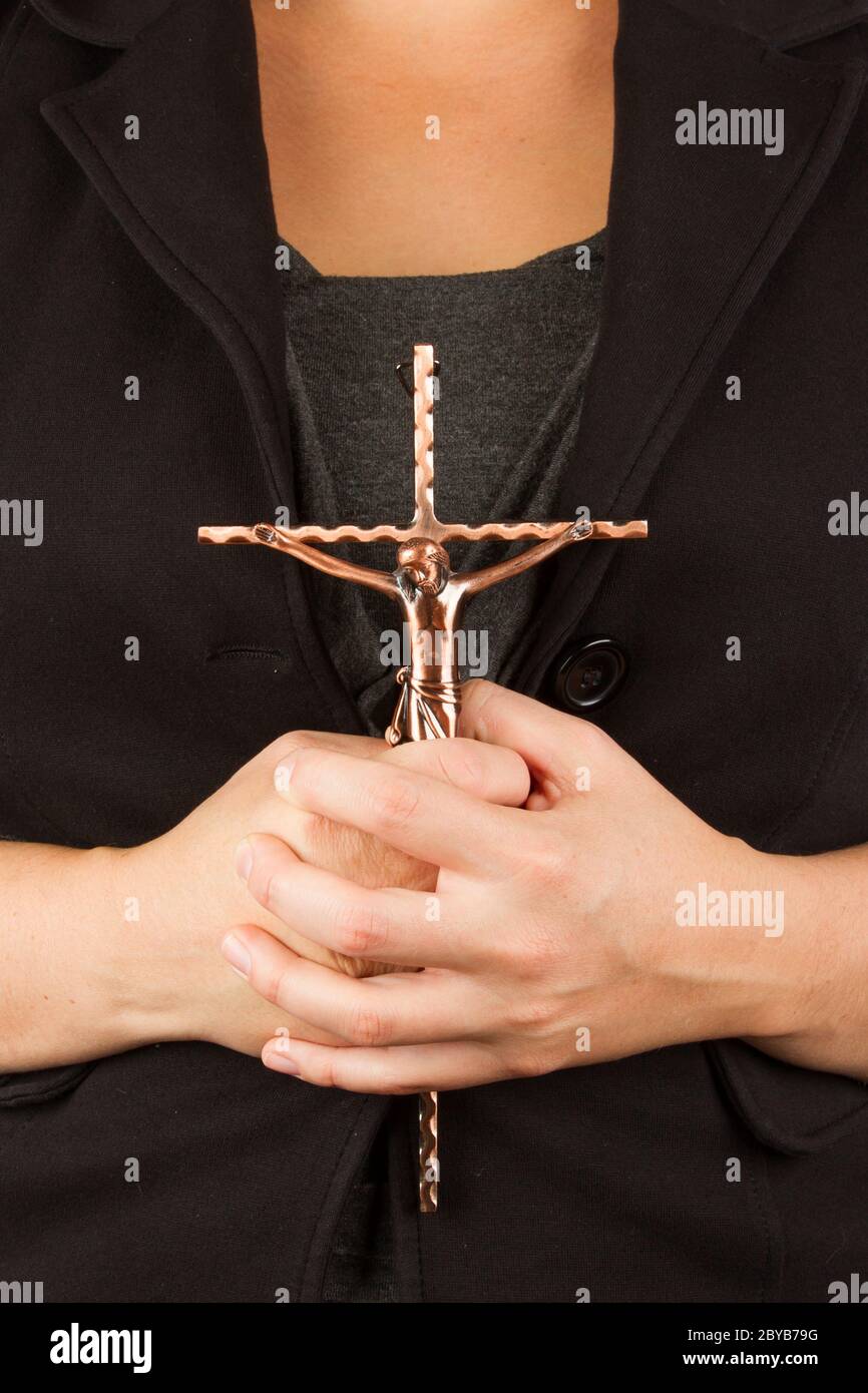 Woman in black with the cross in hands Stock Photo - Alamy