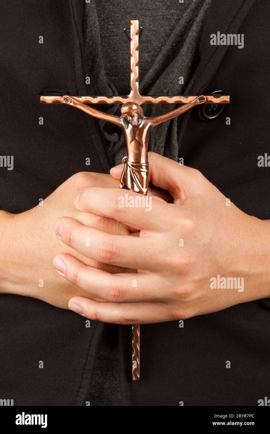 Woman in black with the cross in hands Stock Photo - Alamy