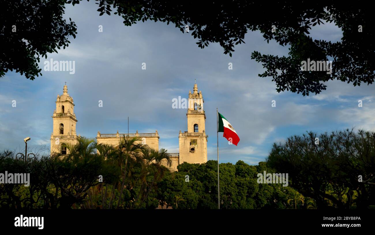 Facade of the cathedral of Merida 'San Ildefonso' and waving Mexican ...