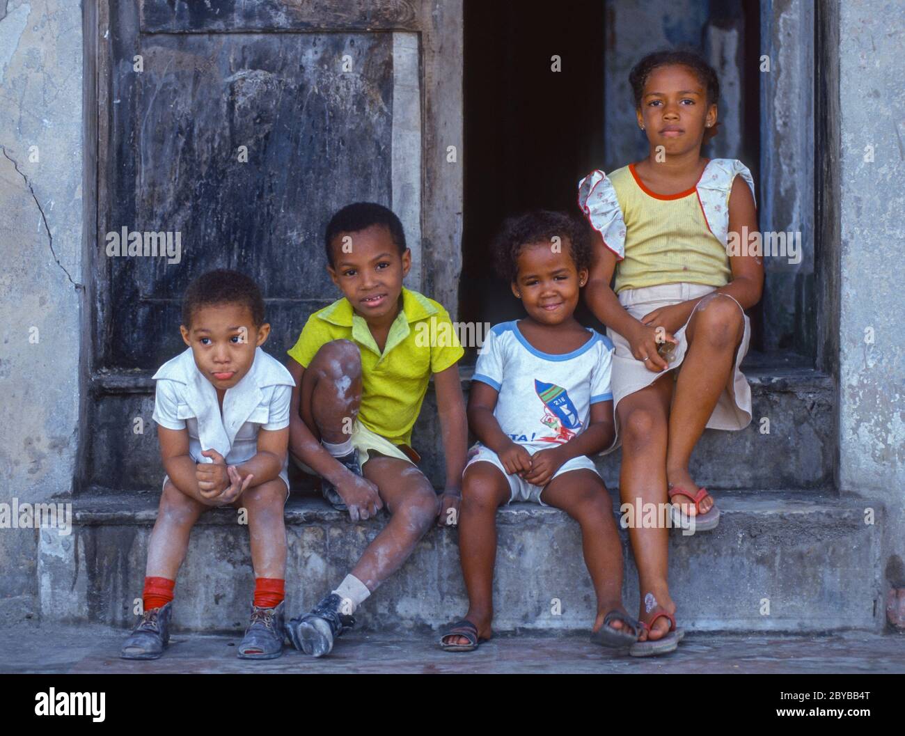 HAVANA, CUBA - Four children sitting on door step on Malecon Stock ...