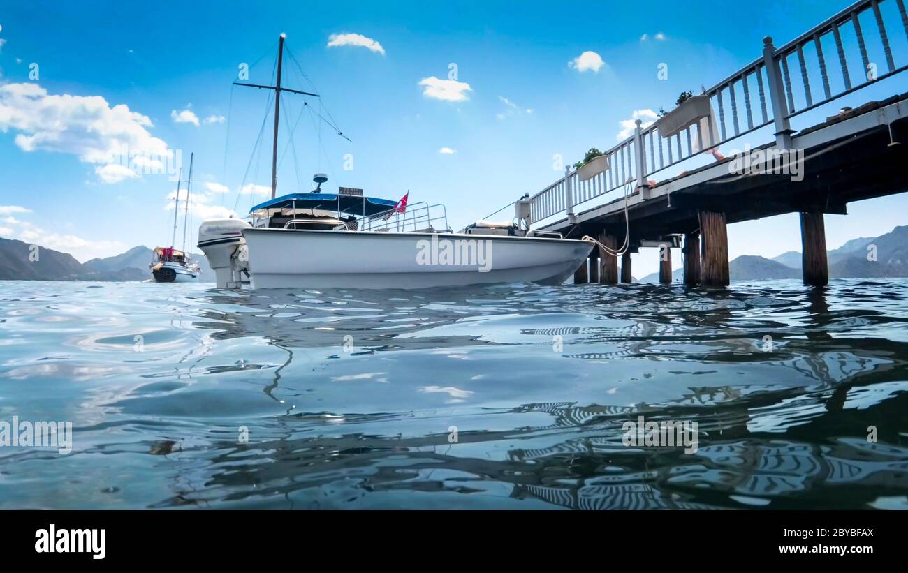 View from the water level on yachts and boats moored at wooden pier in ...