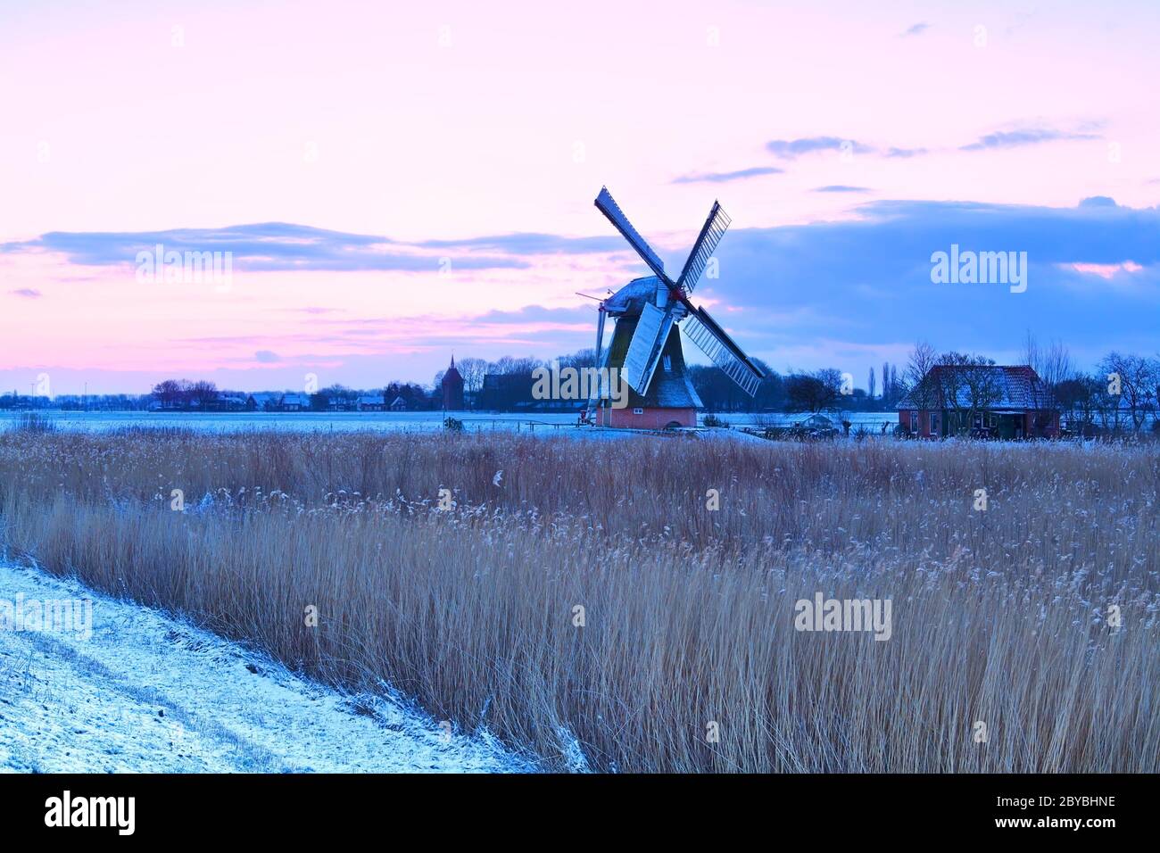 Dutch windmill in winter at sunrise Stock Photo - Alamy