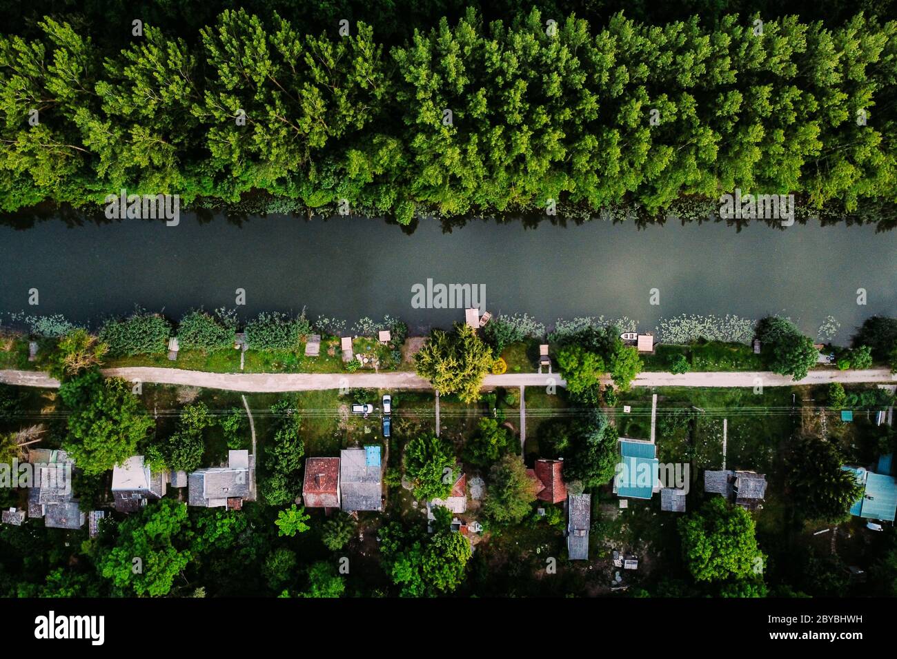 Aerial view of a houses looking in a small river in the forest with a ...